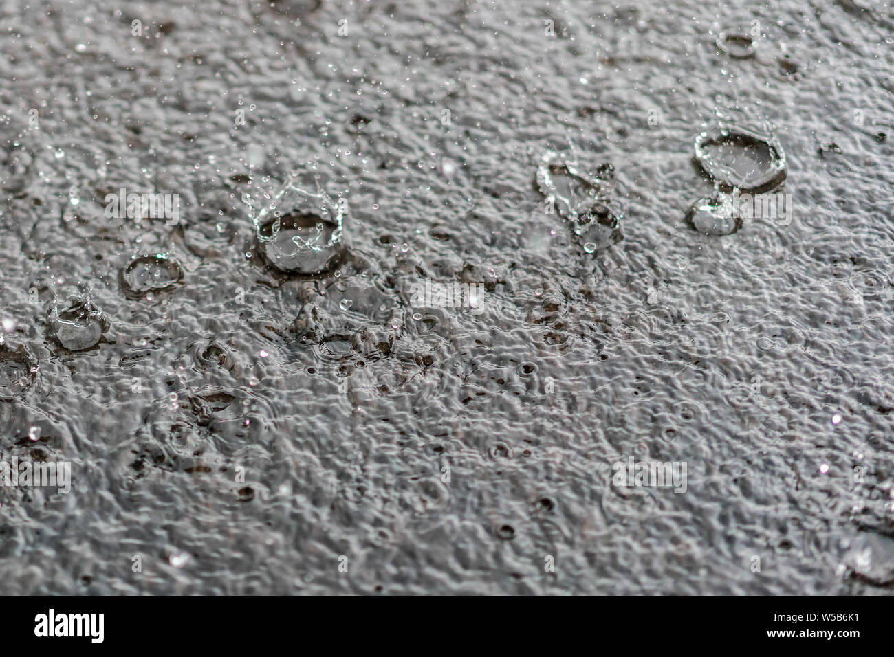 rain gray background. Drops on a puddle Stock Photo - Alamy