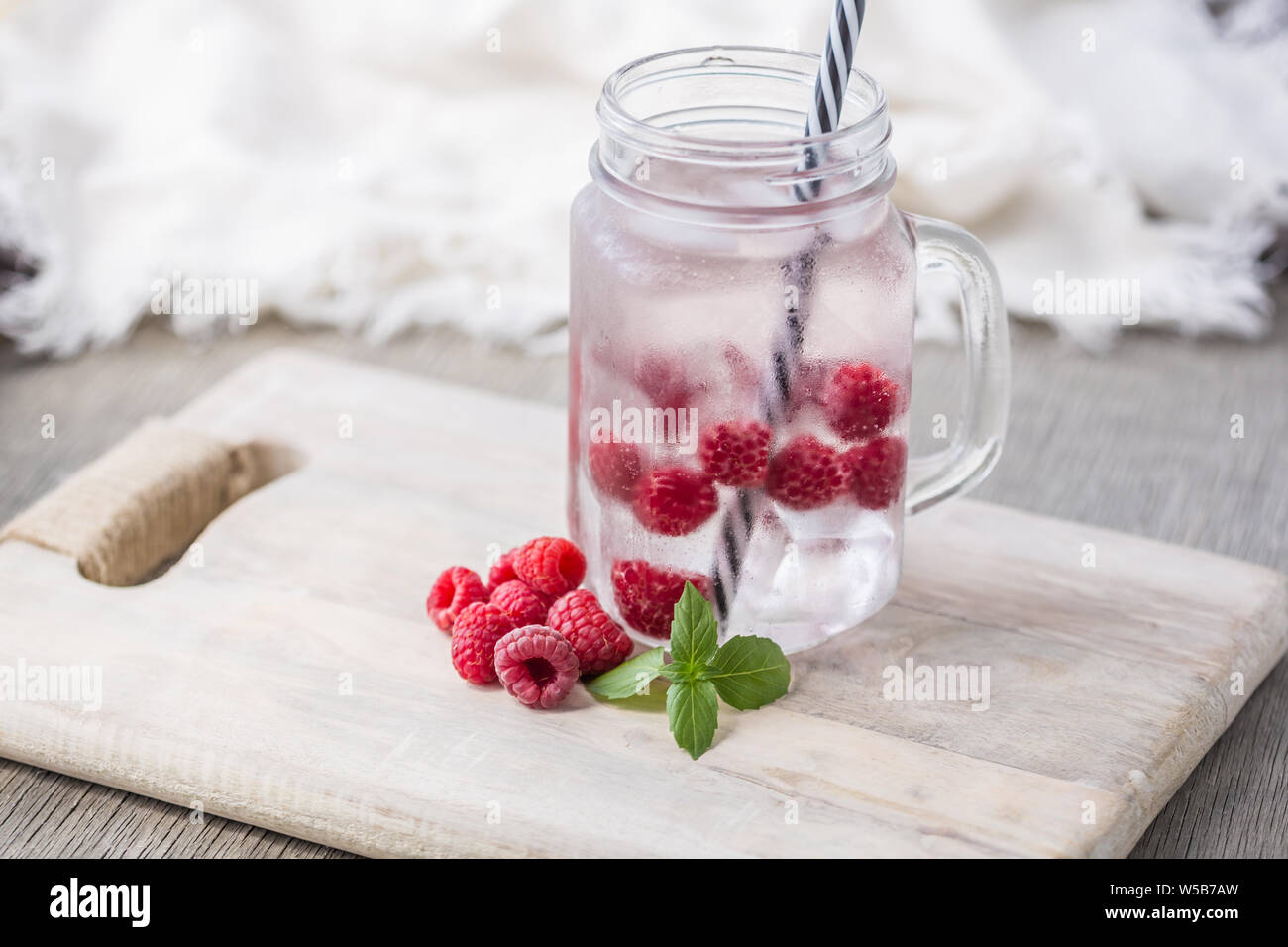 Home fizzy drink with ice and raspberry on a light background ...