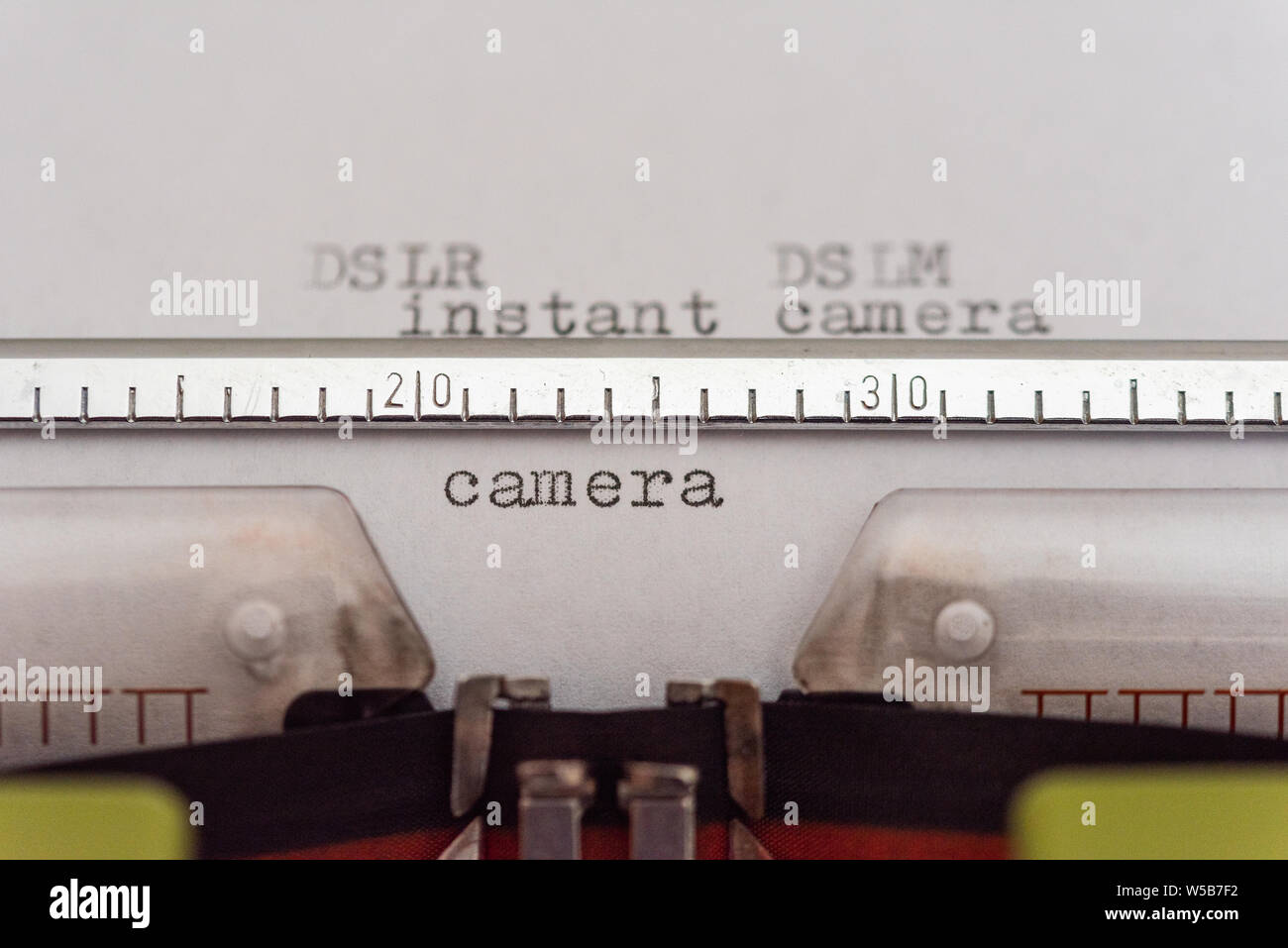 Typewriter with a leaf and the words DSLR, DSLM, instant camera and ...