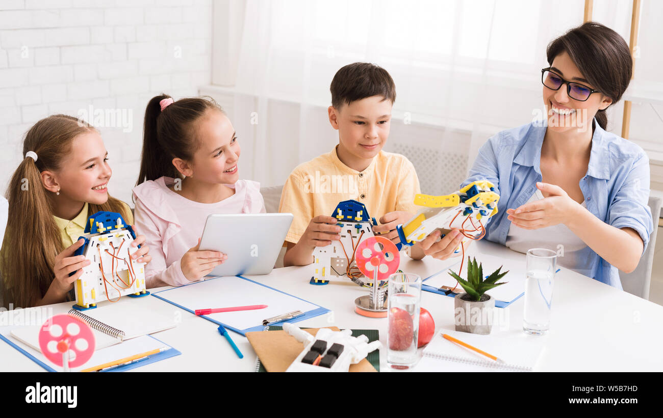 Kids creating robots with teacher in classroom Stock Photo - Alamy