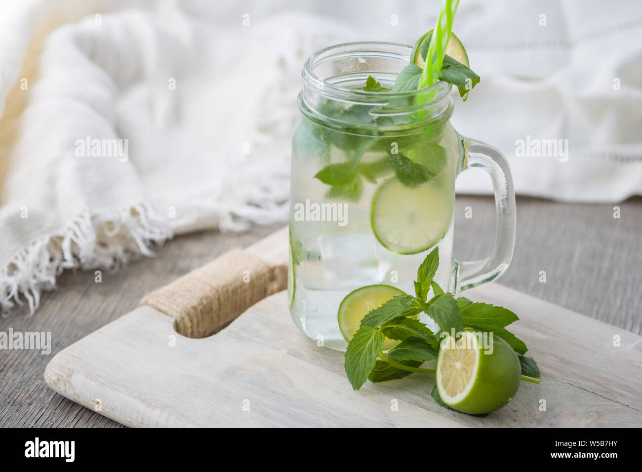 Home fizzy drink with ice lime and mint on a light background ...