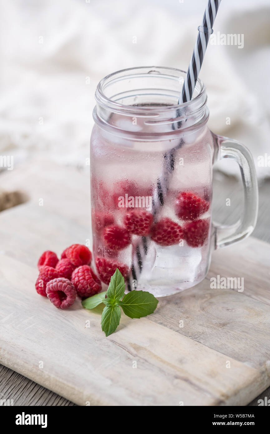 Home fizzy drink with ice and raspberry on a light background ...