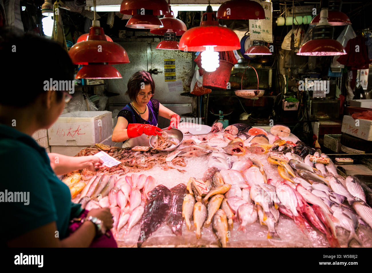 Fishmonger cutting a piece of fresh fish at Fa Yuen market. Hong Kong ...