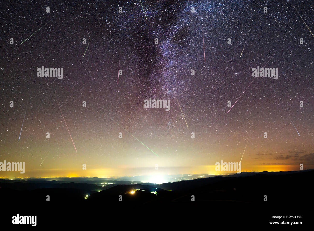 A view of a Meteor Shower and the Milky Way with an illuminated city ...