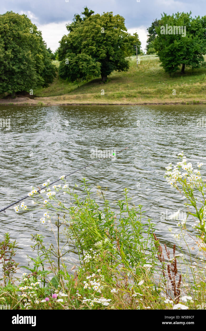 Fishing rod with a bell in the water, fishing in summer Stock Photo - Alamy
