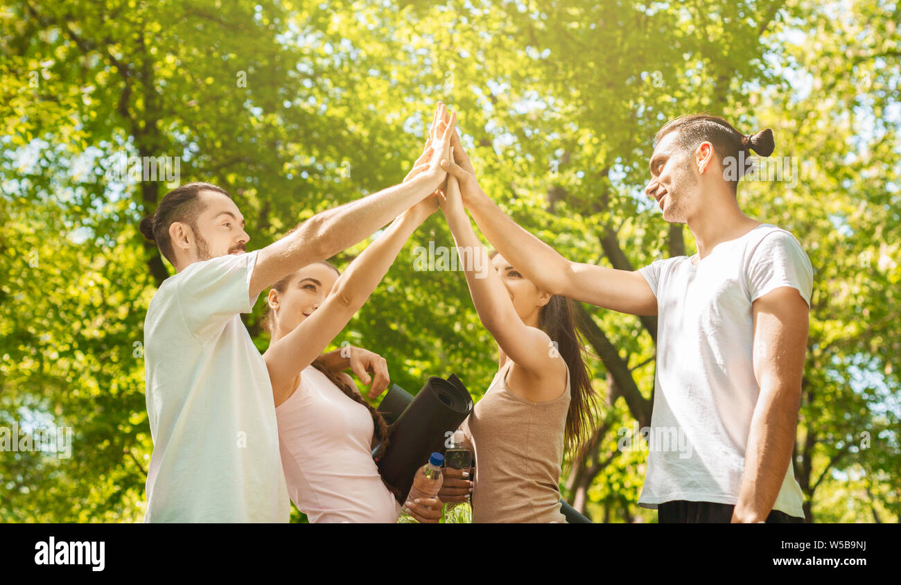 Excited young people giving high five after successful training ...