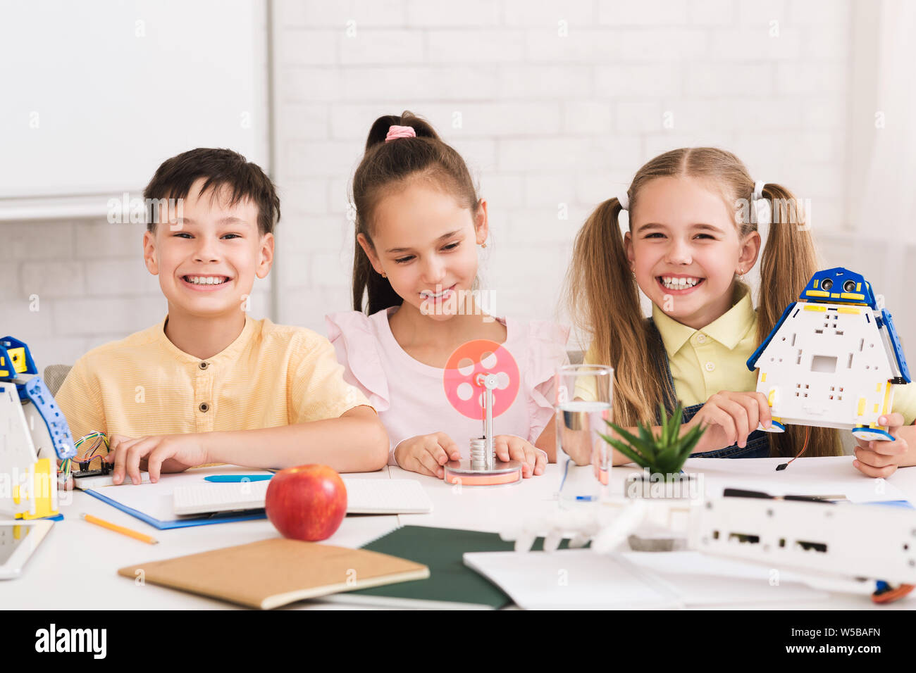 Cheerful children at stem class creating robots Stock Photo - Alamy