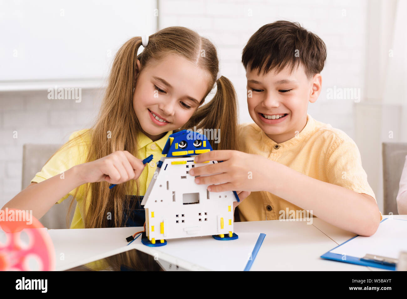 Happy kids constructing robotic toy at stem class Stock Photo - Alamy