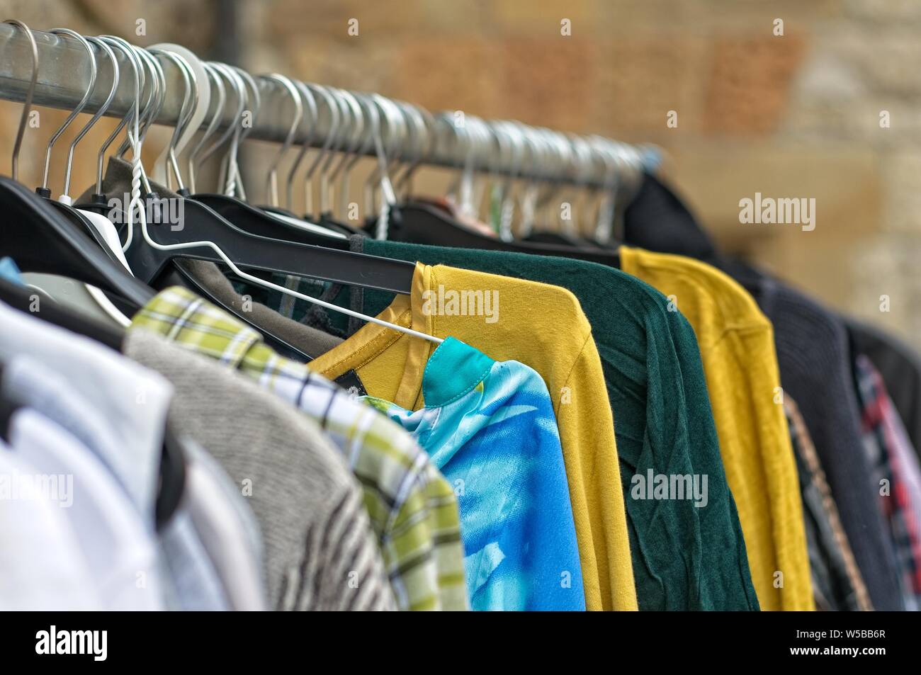 used cloting on a rail Stock Photo - Alamy