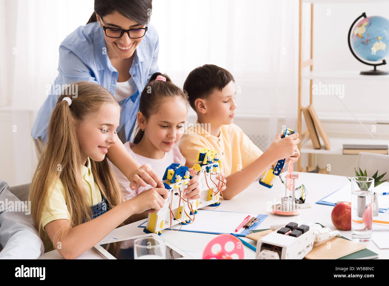 Teacher helping her students with diy robots Stock Photo - Alamy