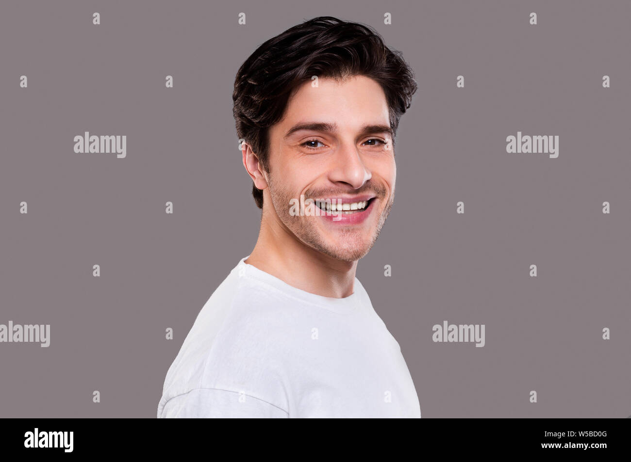 Semi profile portrait of cheerful caucasian guy Stock Photo - Alamy