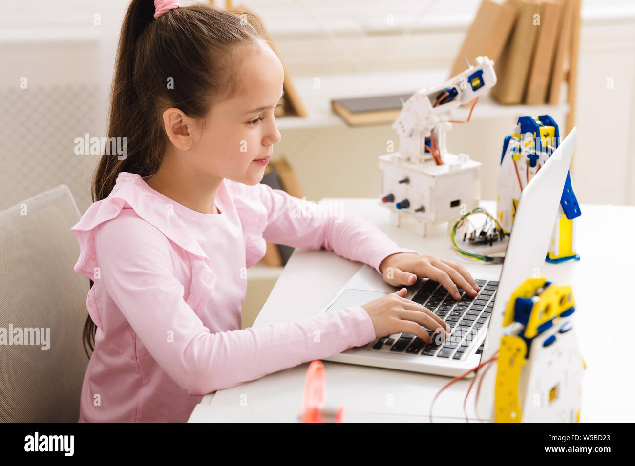 Creating robotics project. Girl typing plan of robot model Stock Photo ...