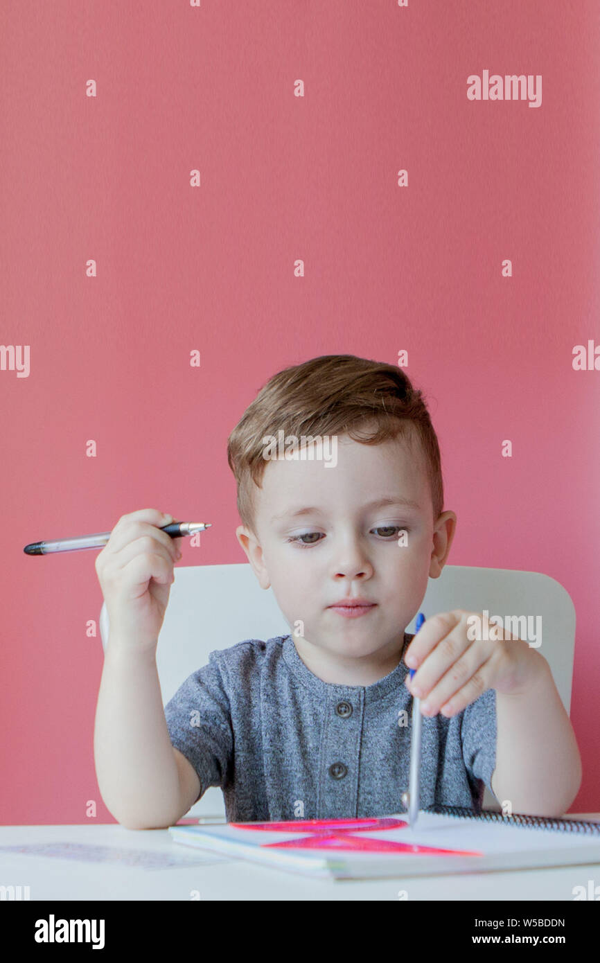 Portrait of cute kid boy at home making homework. Little concentrated ...