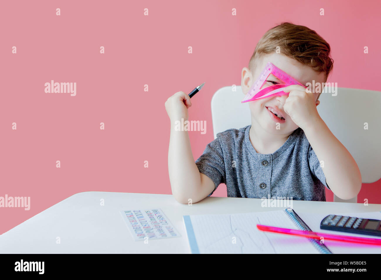 Portrait of cute kid boy at home making homework. Little concentrated ...