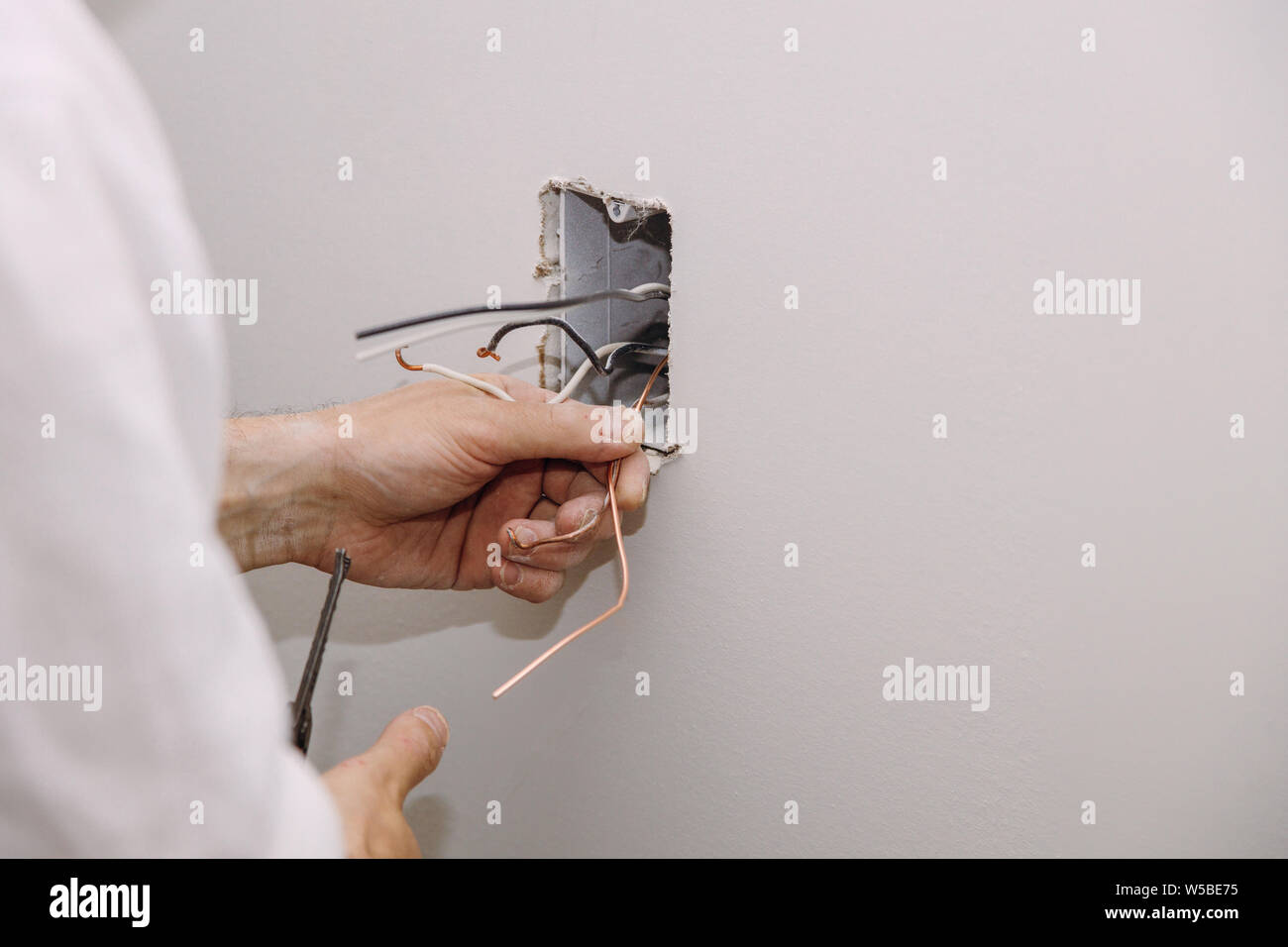 Unfinished electrical mains outlet socket with electrical wires and ...