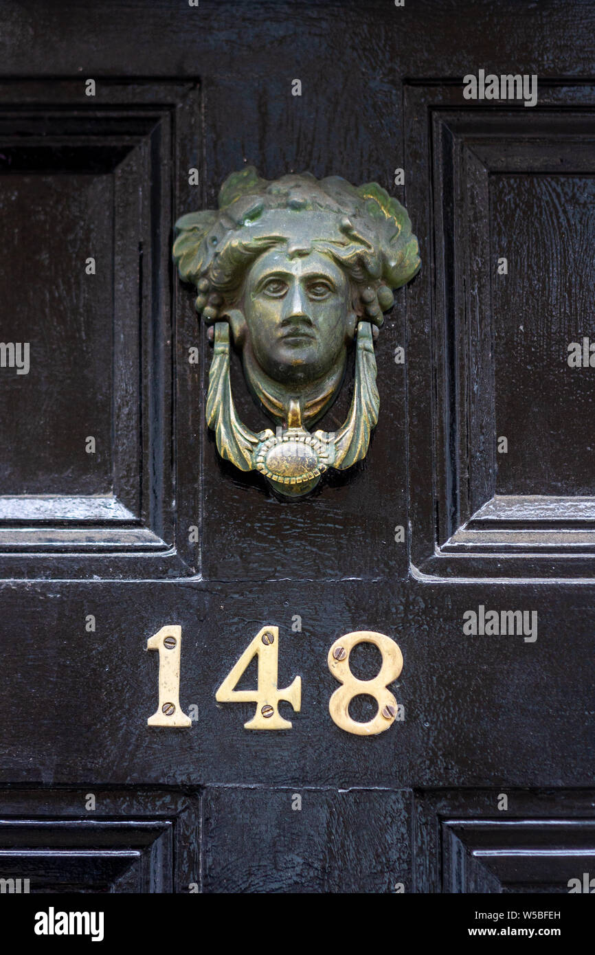 House number 148 on a black wooden front door with a door knocker in ...