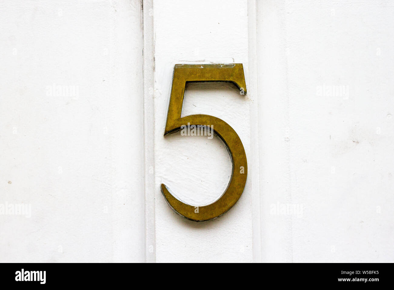 House number 5 in bronze on a white door Stock Photo - Alamy