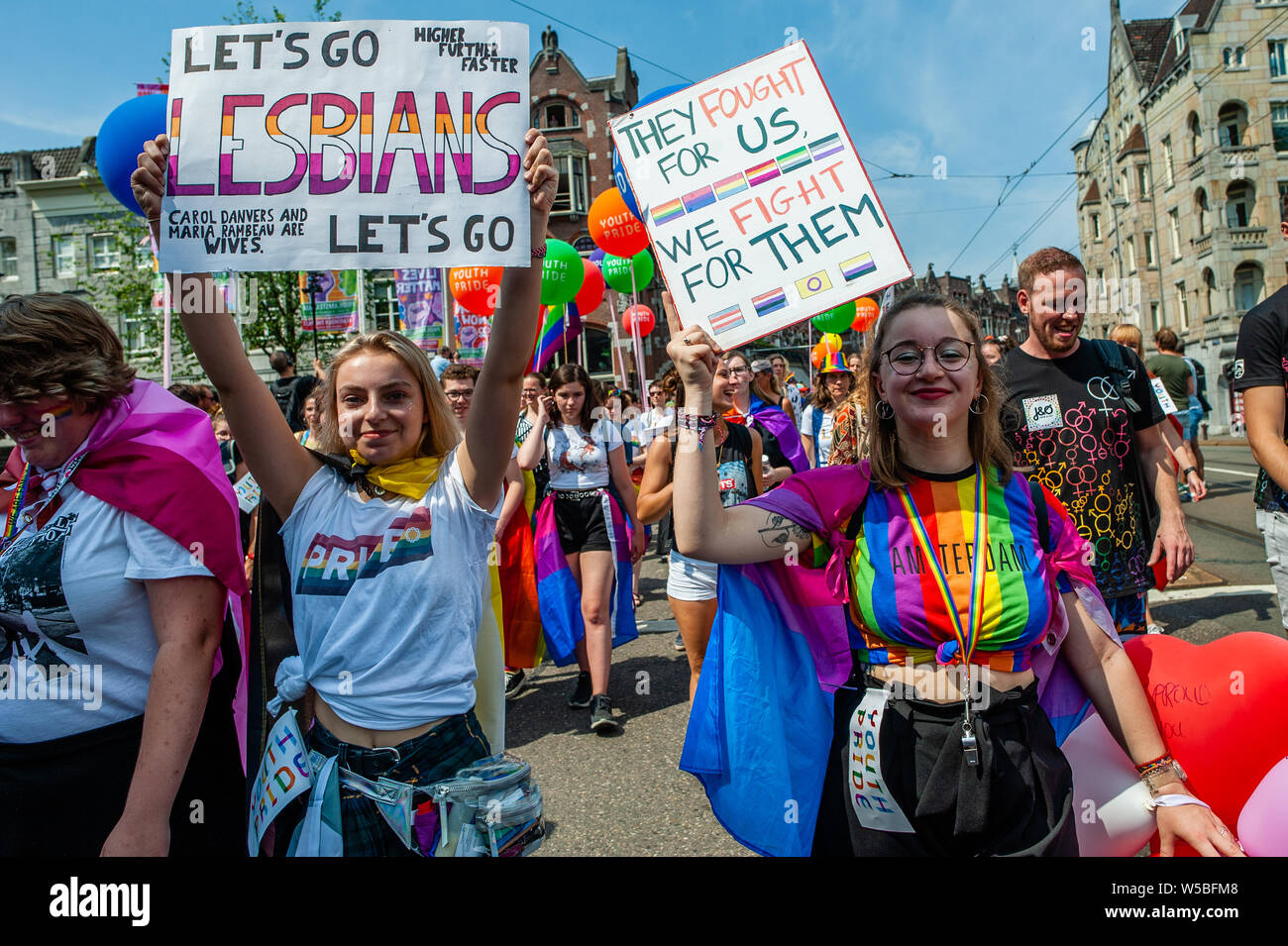 Two young women holding placards during the Pride Walk.Because of the ...