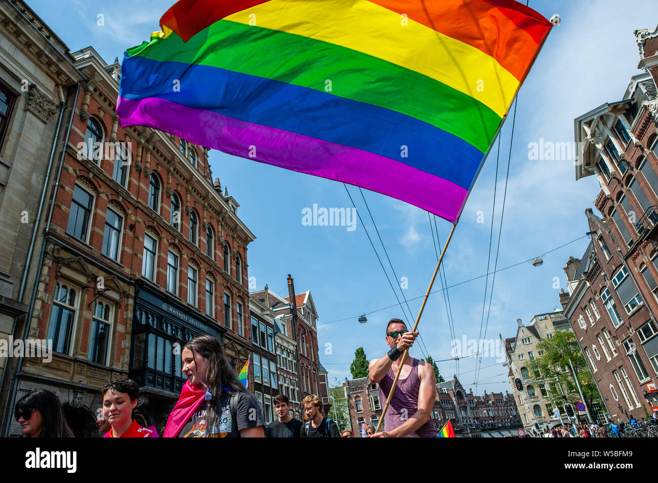 A man waves a rainbow flag during the Pride Walk.Because of the ...