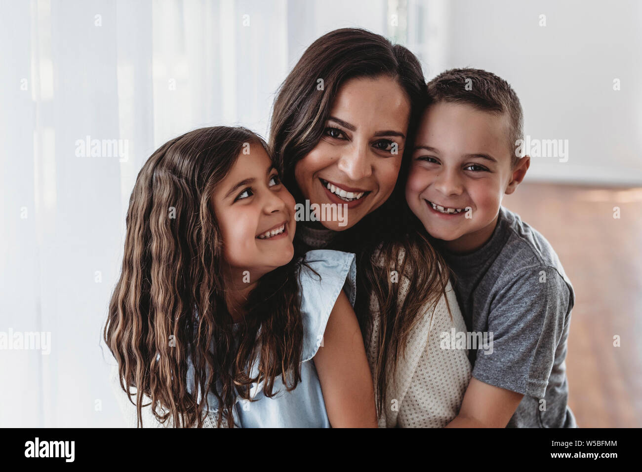 Portrait of family smiling lovingly in natural light studio Stock Photo ...