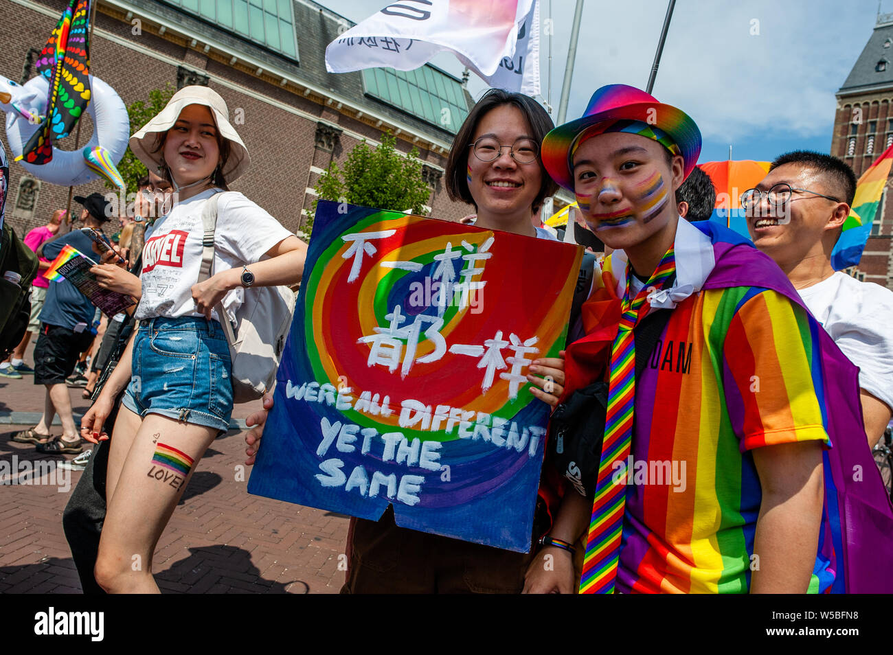 Two Asian people hold a placard during the Pride Walk.Because of the ...