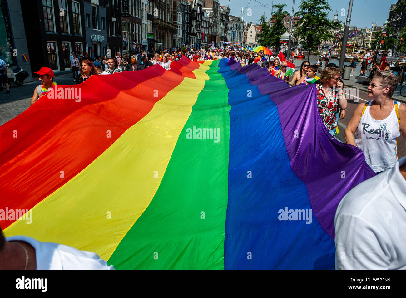 A huge rainbow flag carried by several participants during the Pride ...