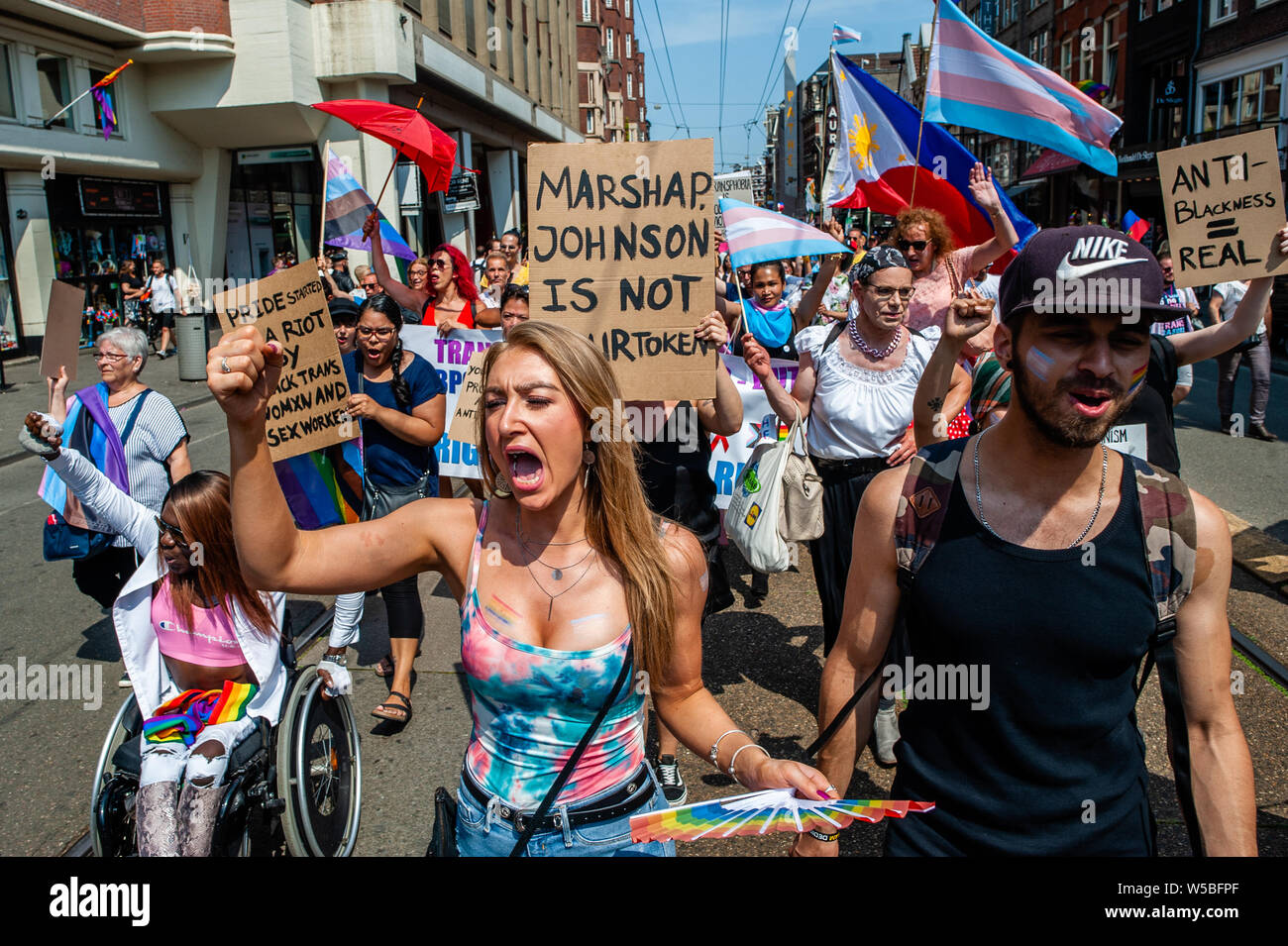 Participants shout slogans while holding placards during the Pride Walk ...