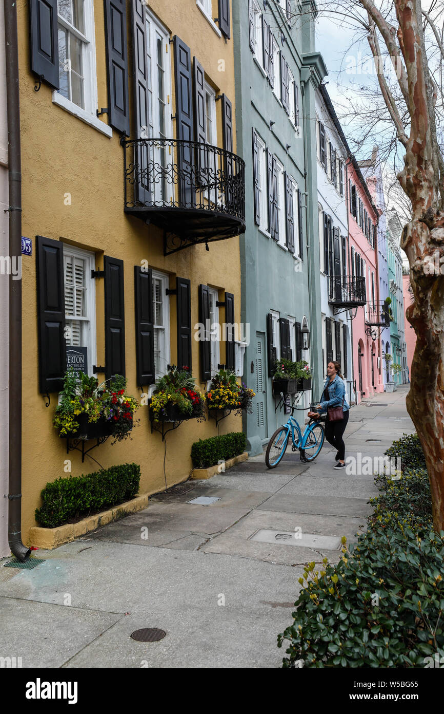 A woman walks her bike in Charleston, South Carolina along brightly ...