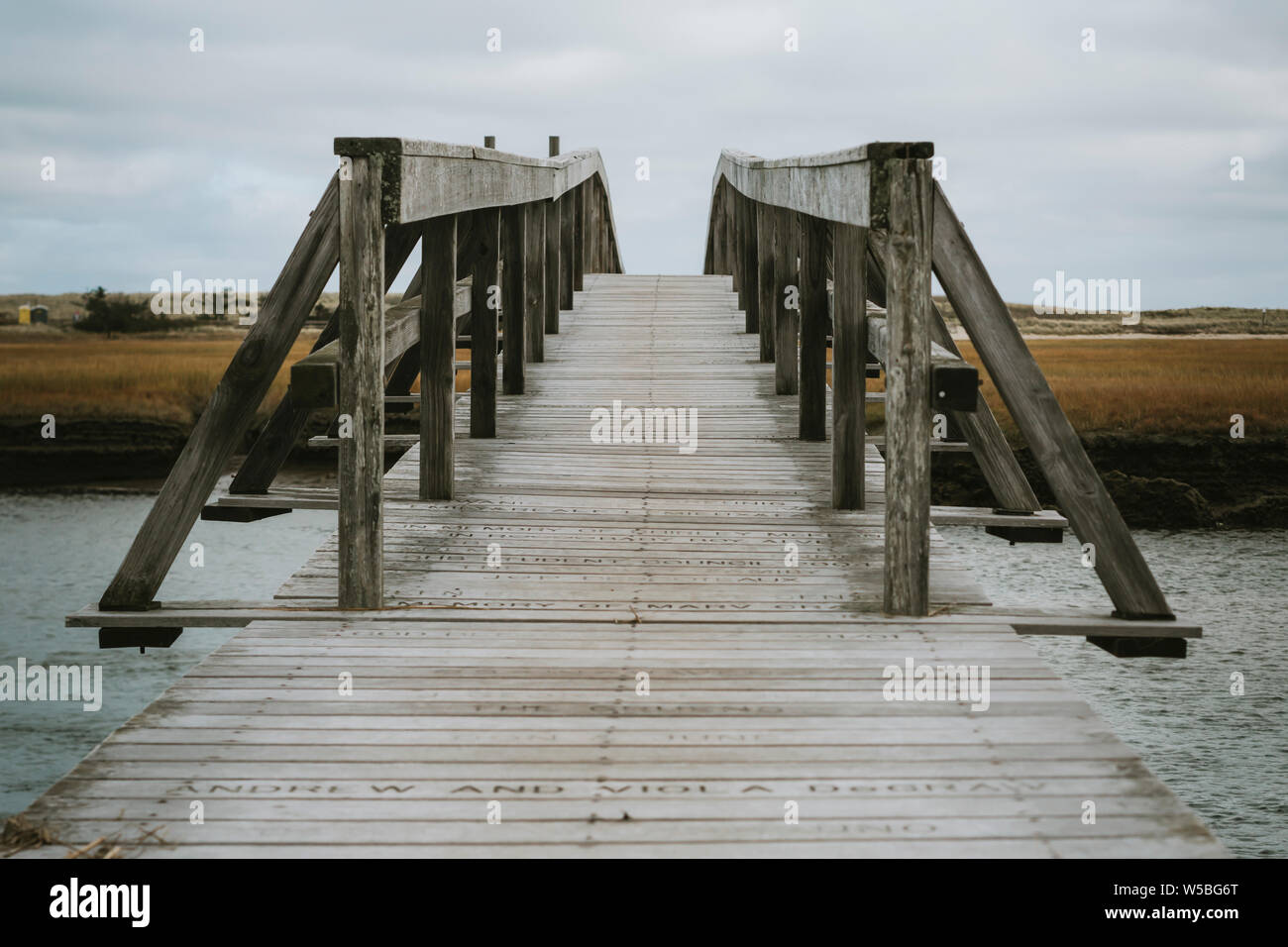 Low angle view of boardwalk bridge over sea inlet and salt marsh Stock ...