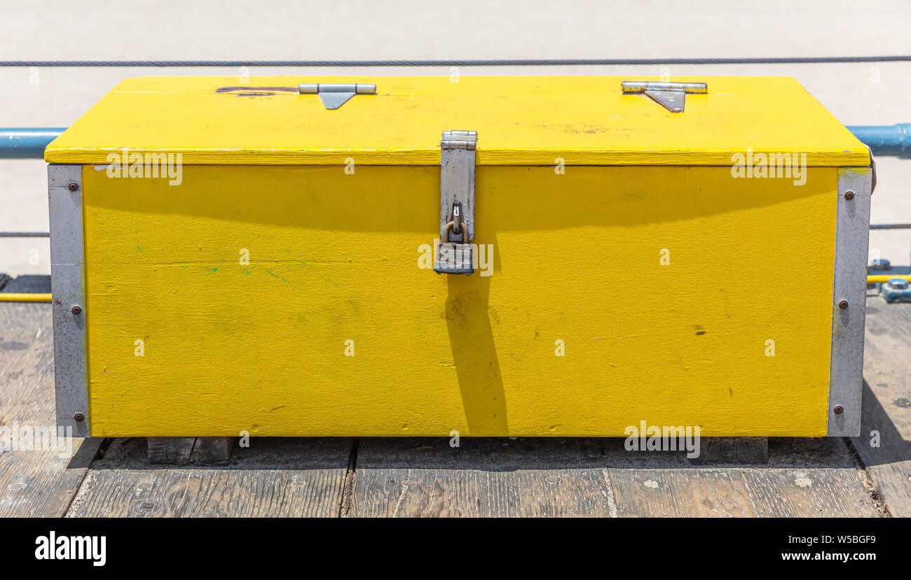 Yellow old wood box locked with rusty padlock. Bright yellow wood trunk ...