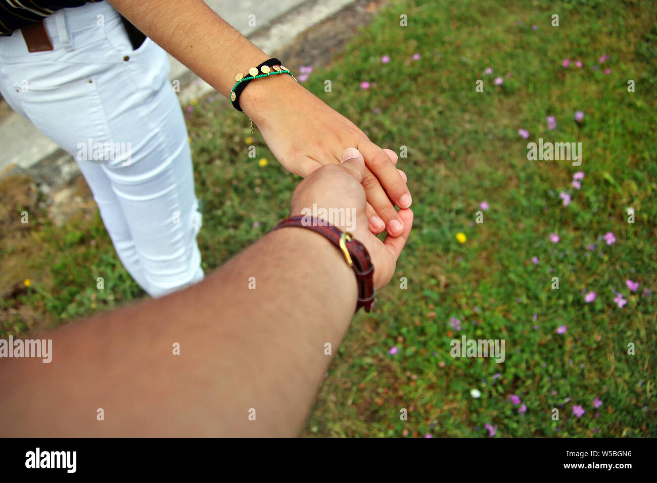 Woman holding her boyfriend's hand Stock Photo - Alamy