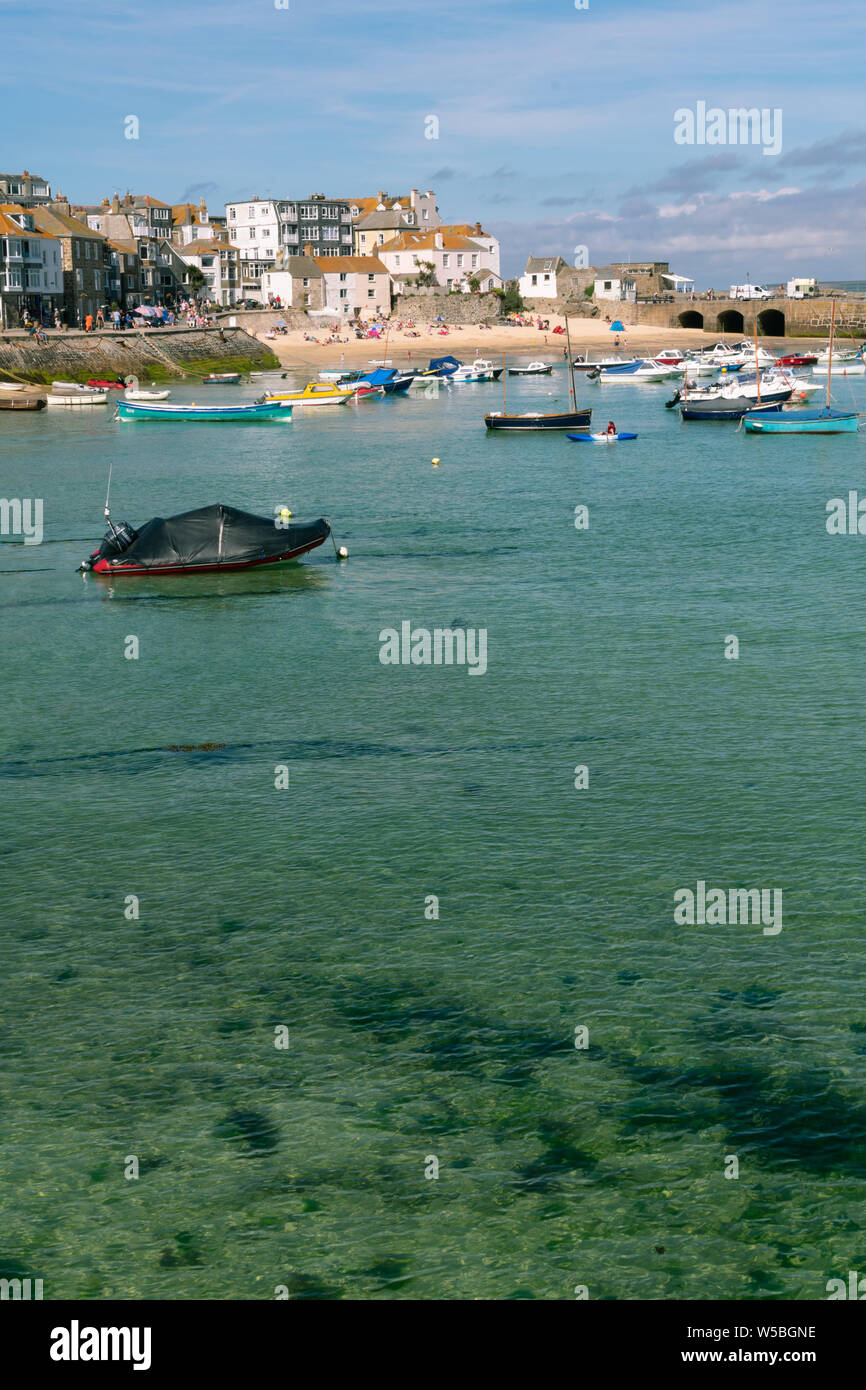 Boat in calm bay by quaint seaside village Stock Photo - Alamy