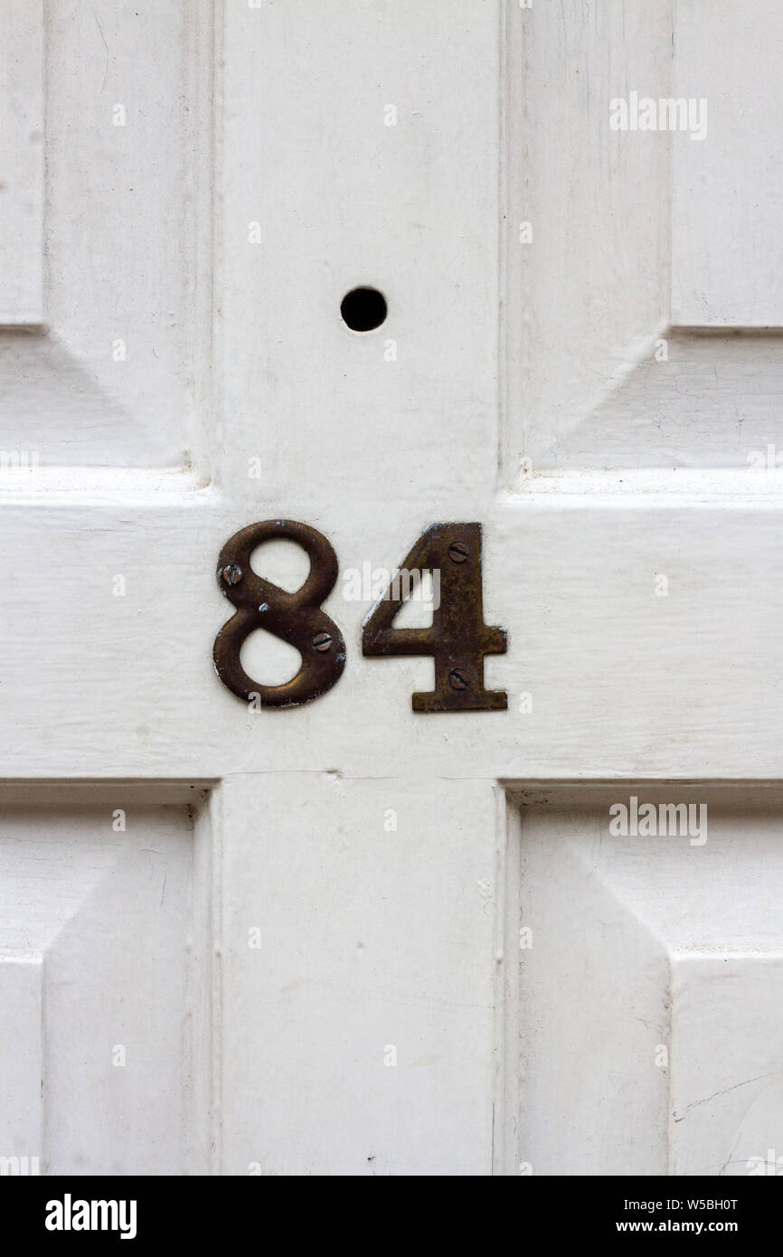 House number 84 on a white wooden front door Stock Photo - Alamy