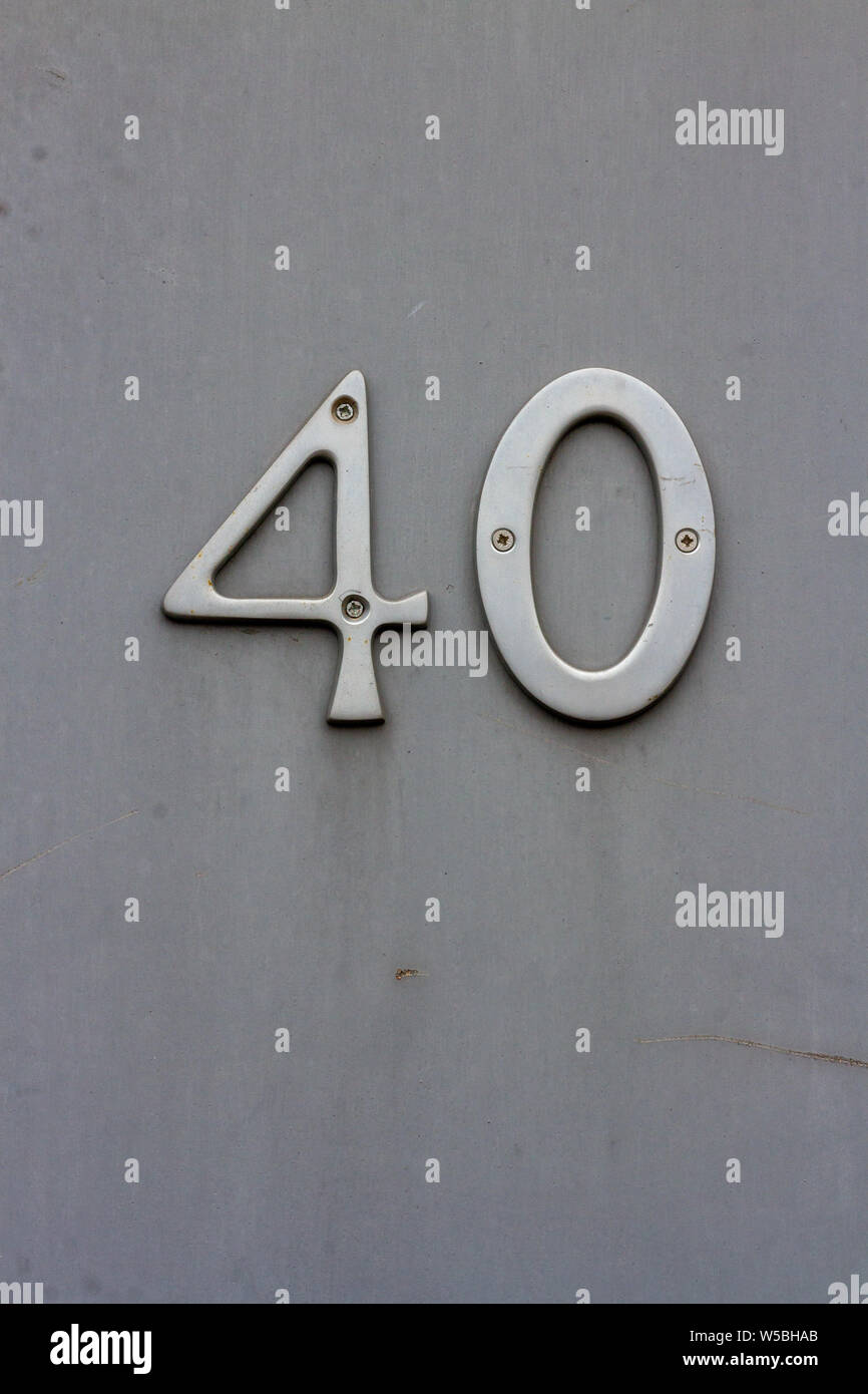 House number 40 with the forty in silver metal digits on a gray wooden ...