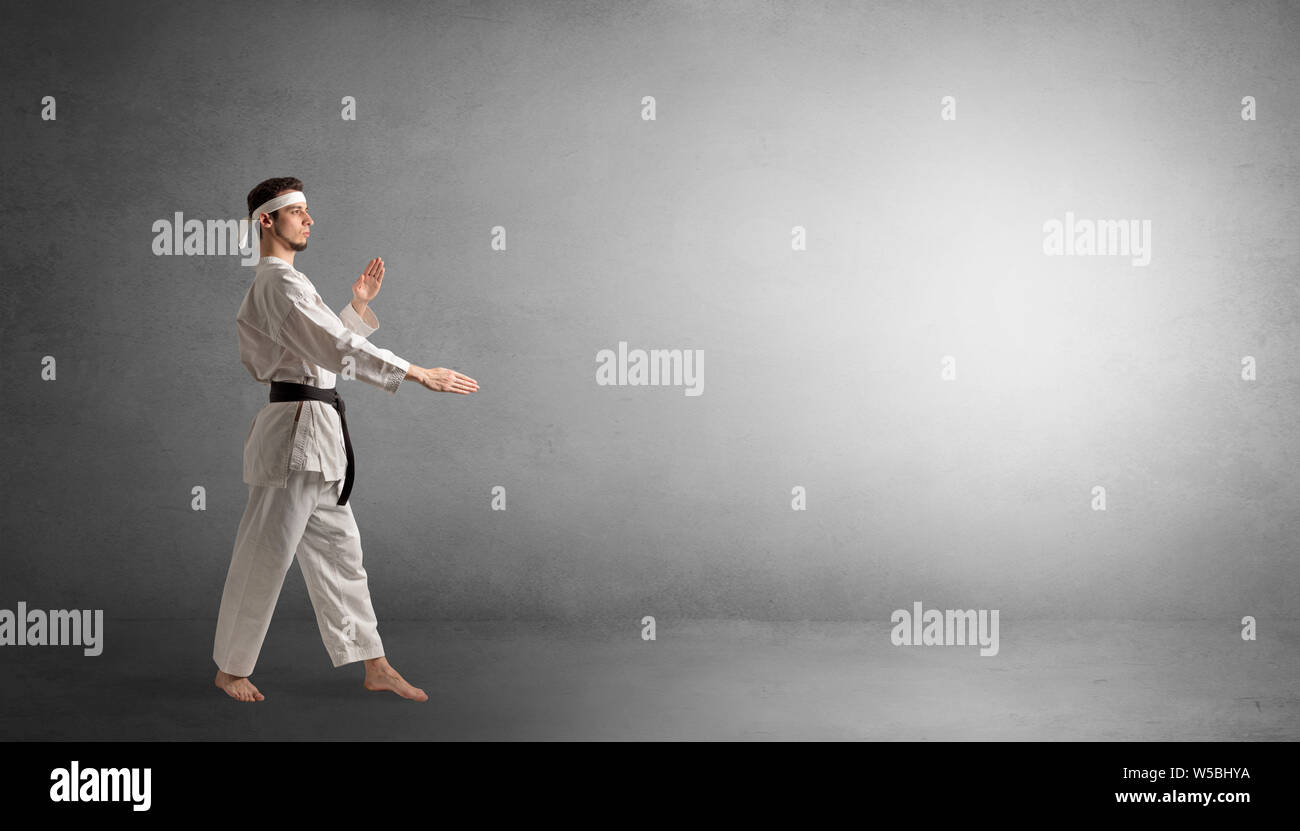 Small karate man fighting in an empty grey copy space Stock Photo - Alamy