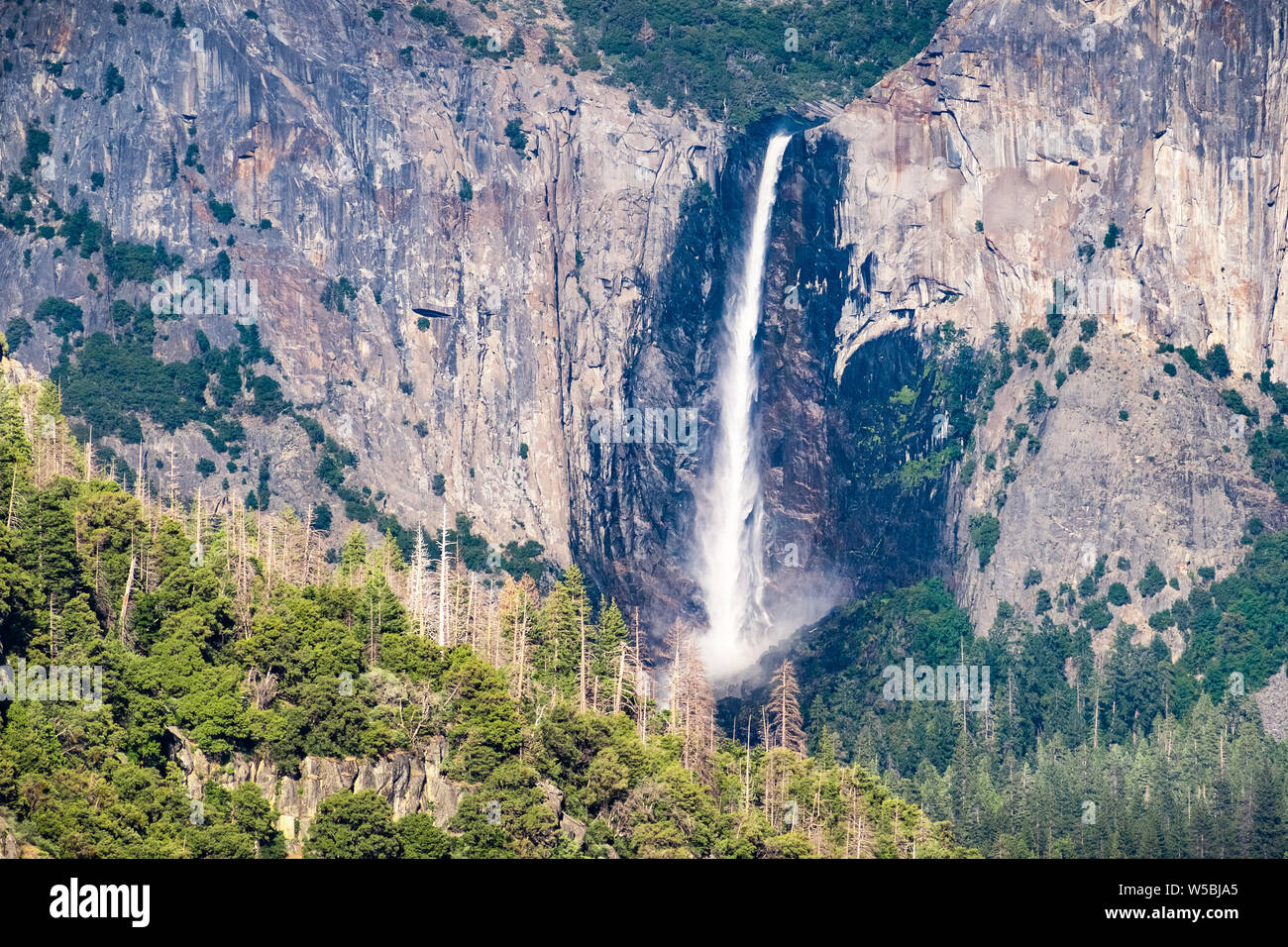 Aerial view of Bridalveil Falls dropping over a colorful rock wall ...