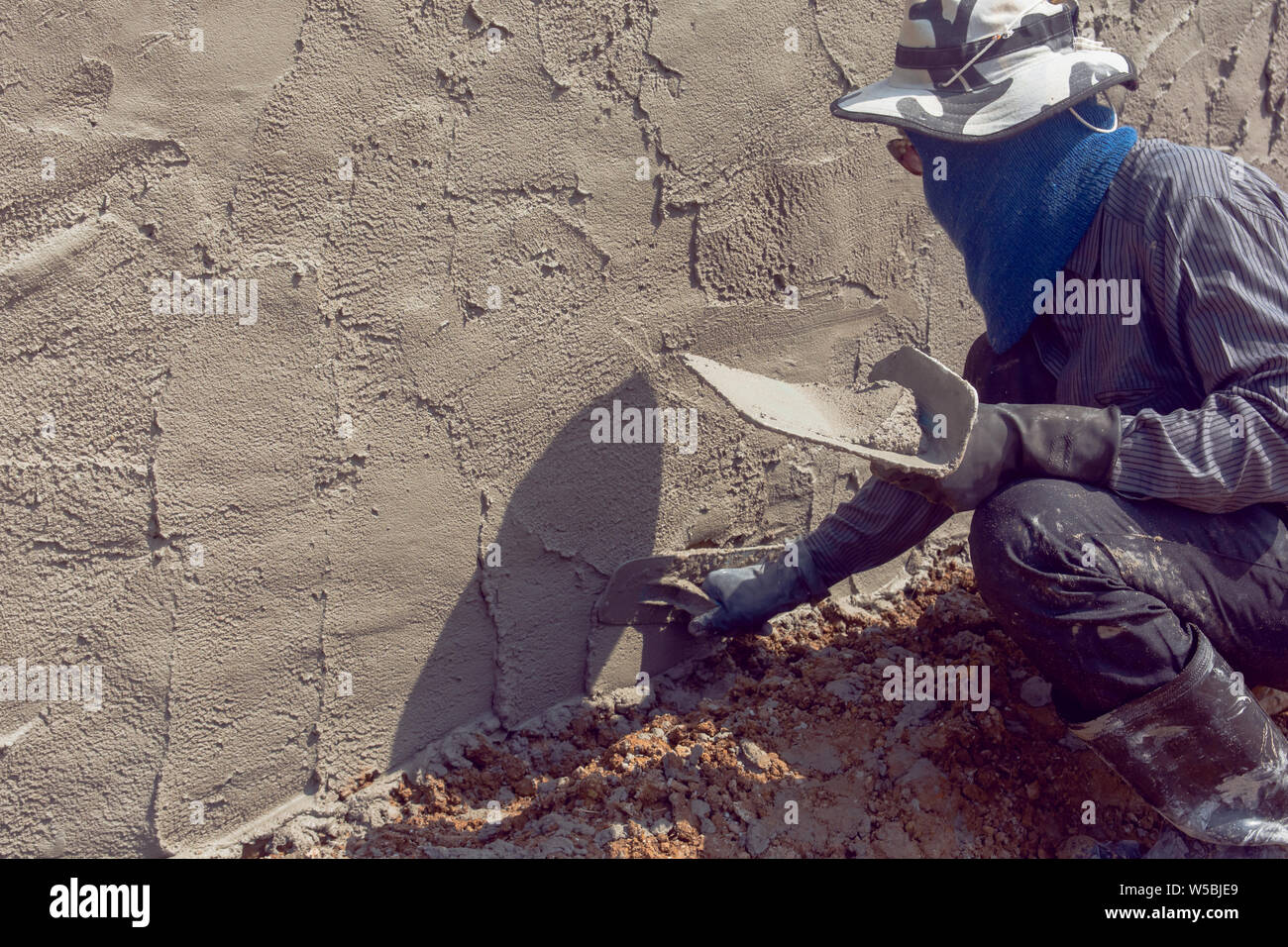 Construction workers plastering building wall using cement plaster ...
