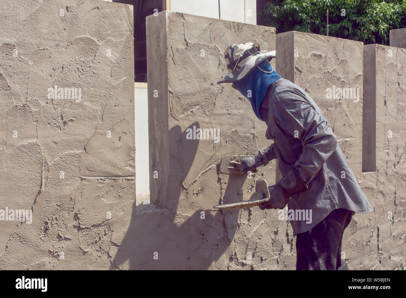 Construction workers plastering building wall using cement plaster ...