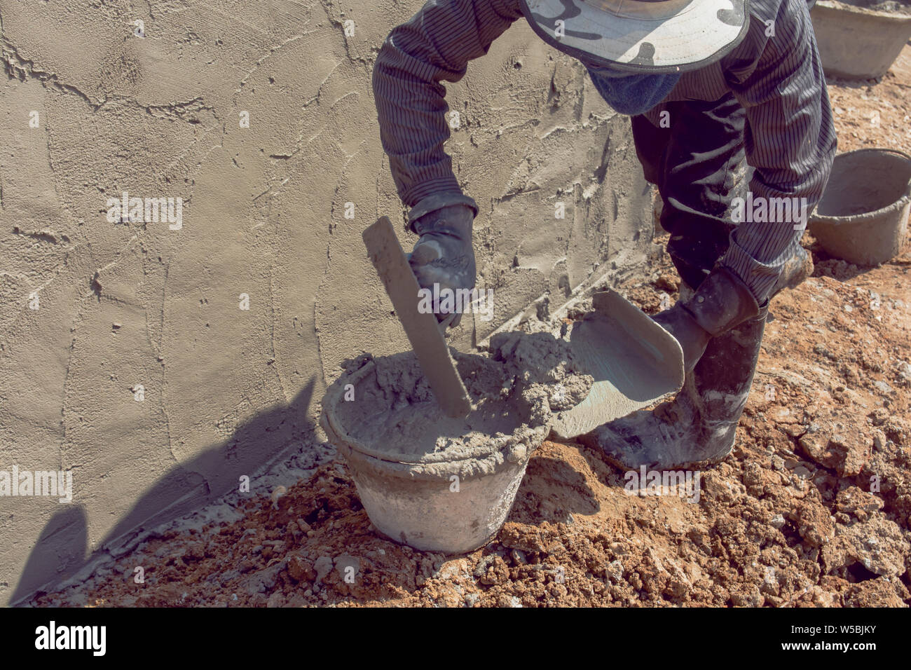 Construction workers plastering building wall using cement plaster ...
