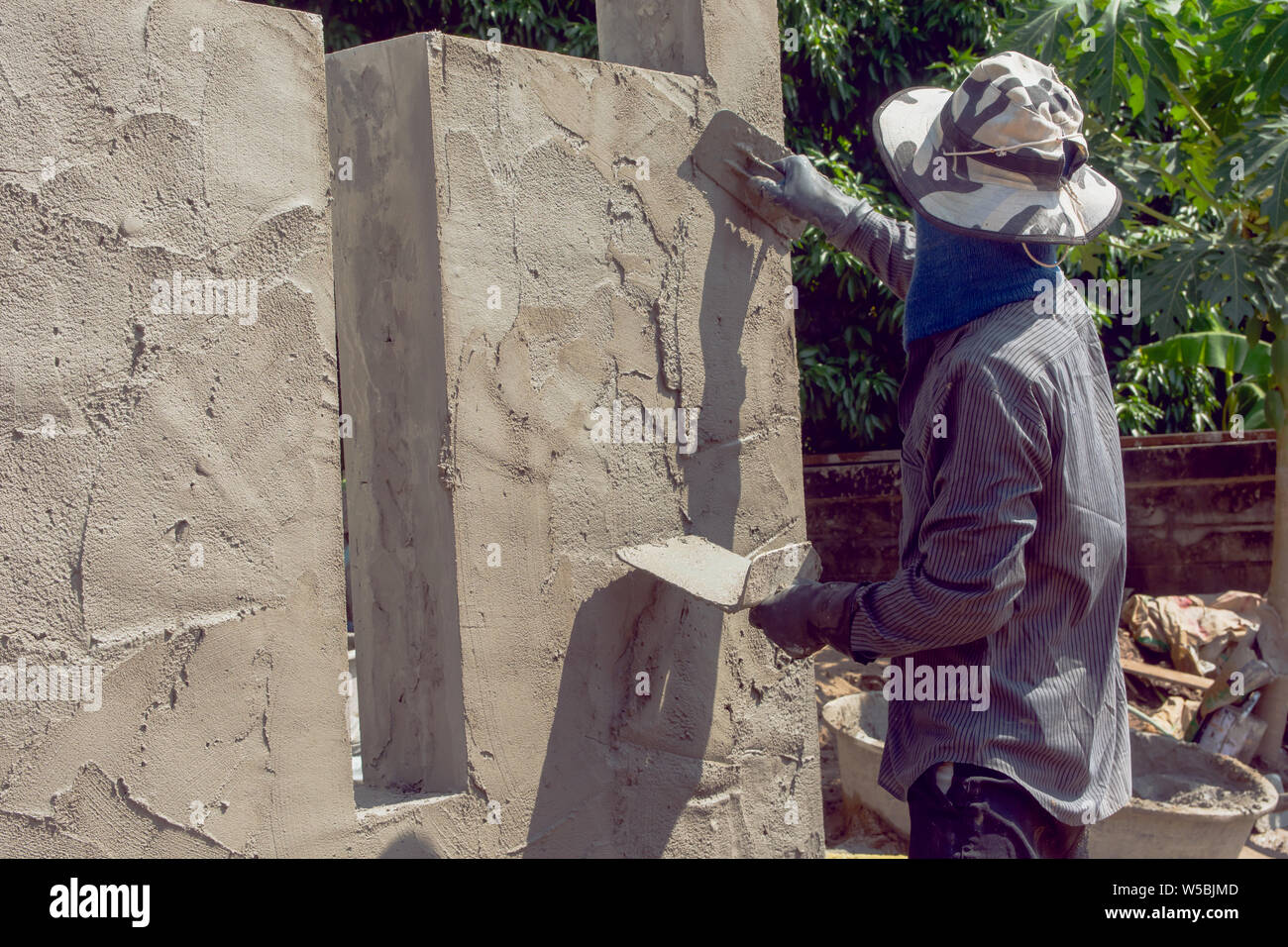 Construction workers plastering building wall using cement plaster ...