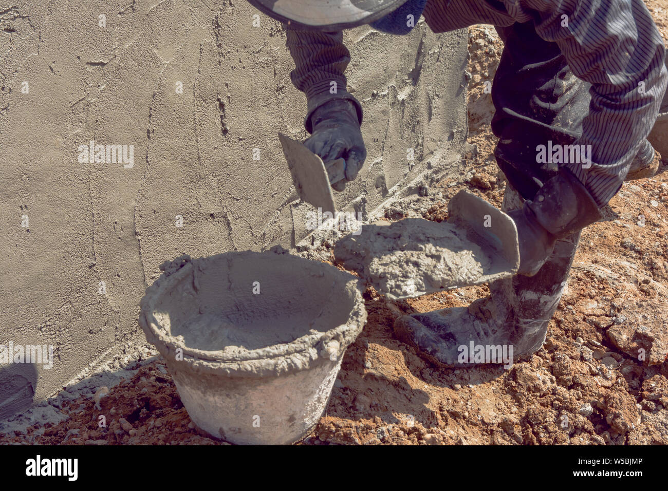 Construction workers plastering building wall using cement plaster ...