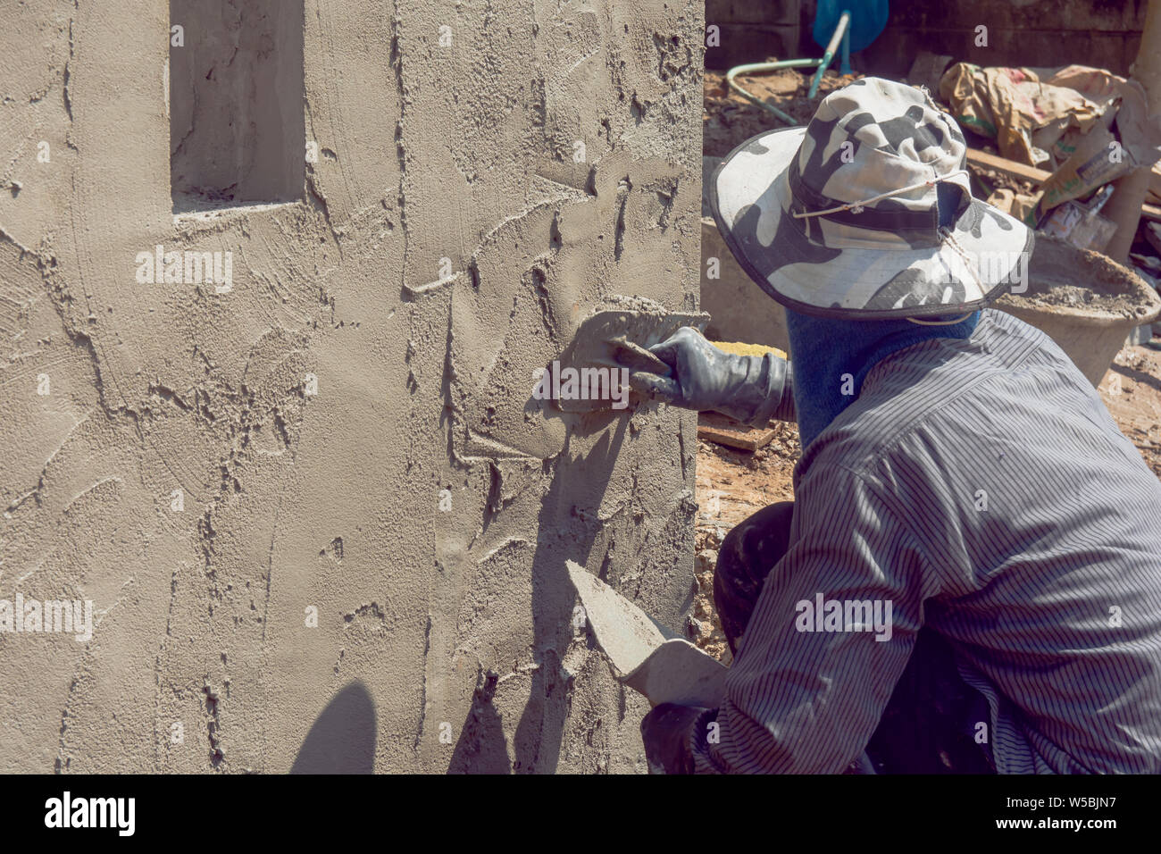Construction workers plastering building wall using cement plaster ...
