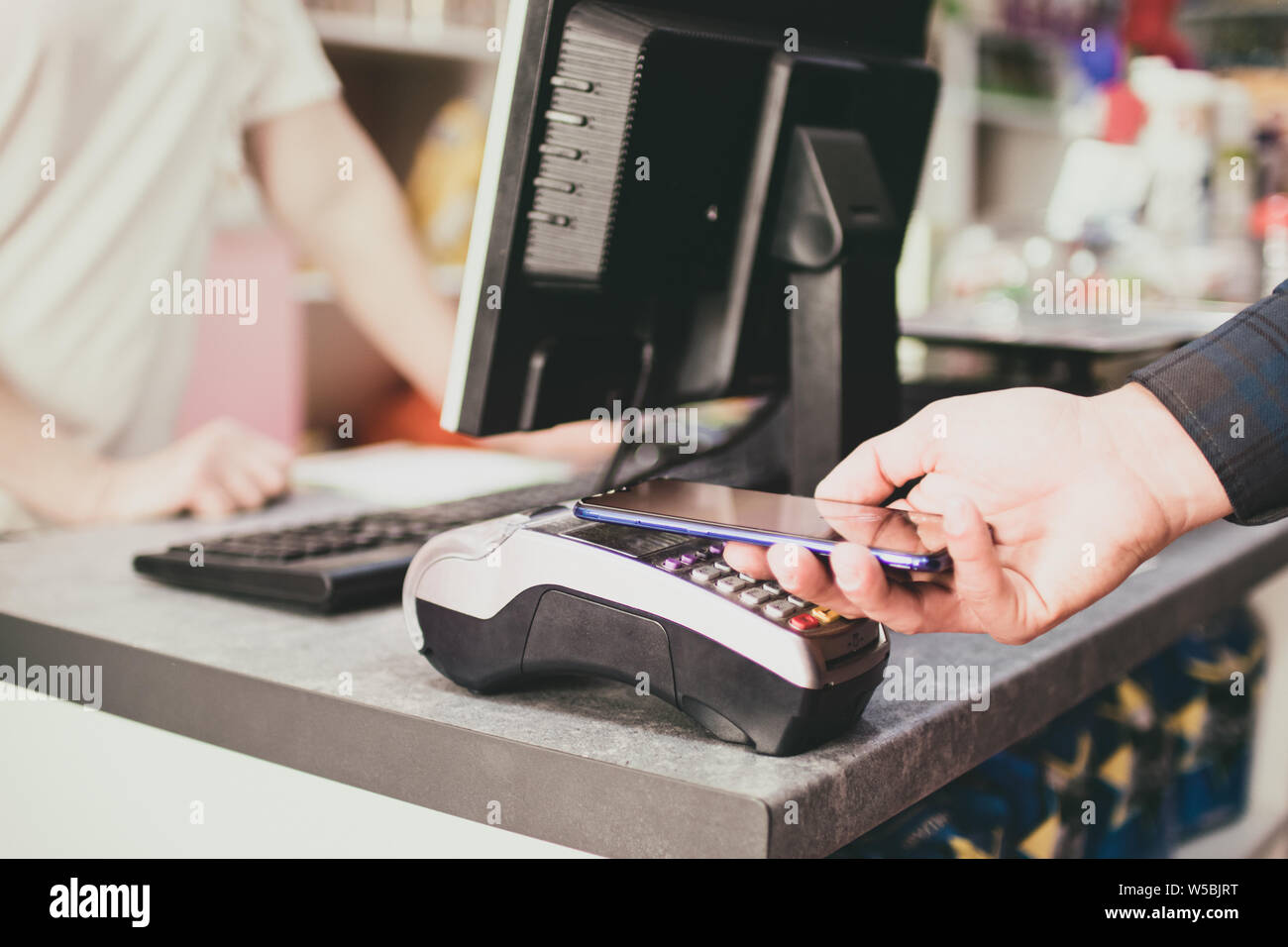 Shopper does payment using smartphone. NFC technology in people life ...