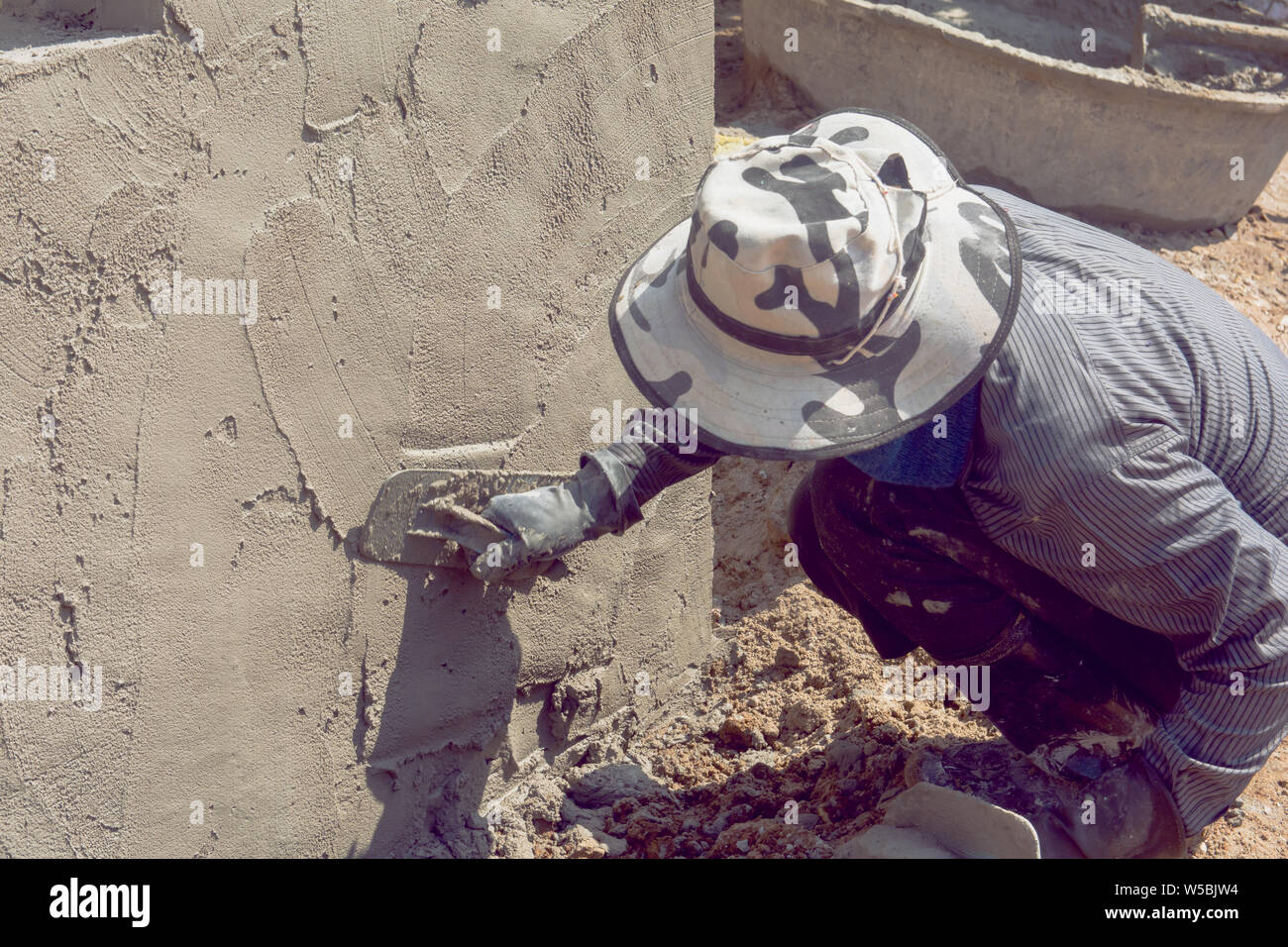 Construction workers plastering building wall using cement plaster ...