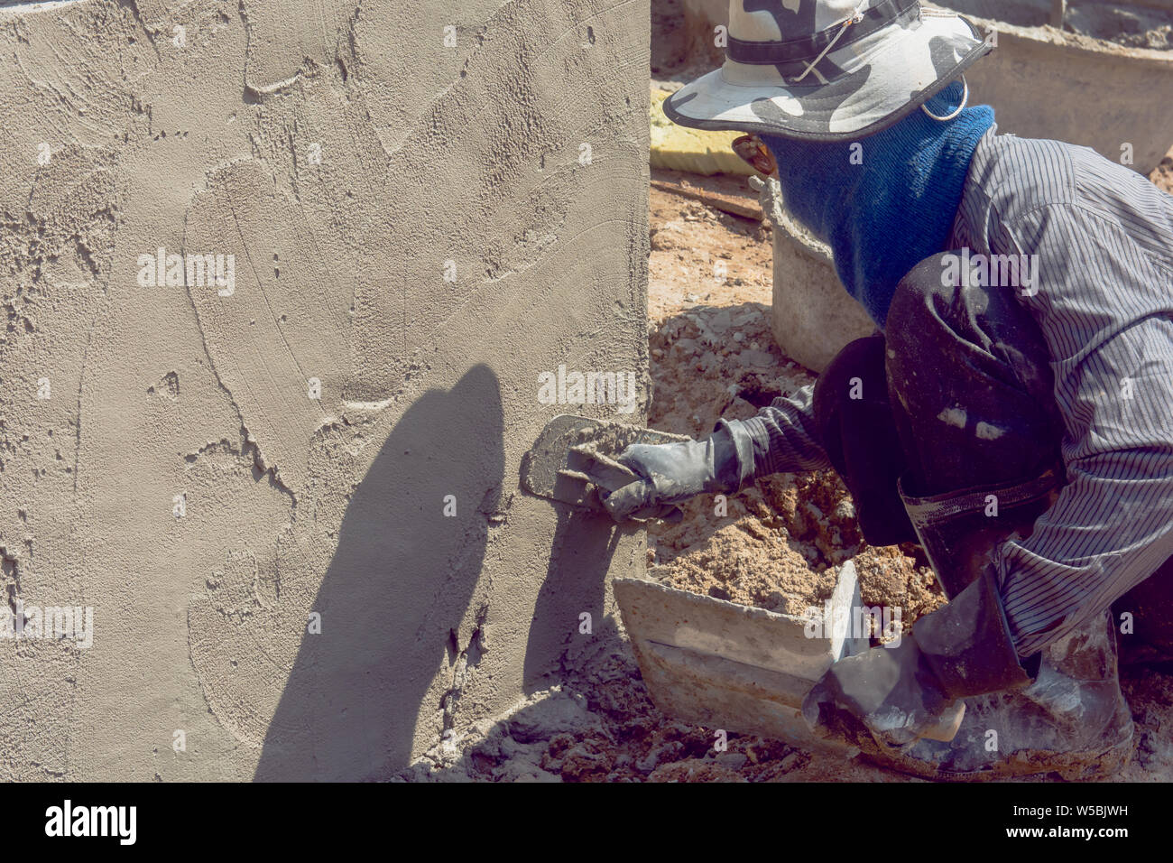 Construction workers plastering building wall using cement plaster ...
