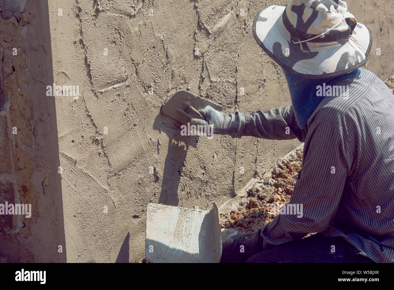 Construction workers plastering building wall using cement plaster ...