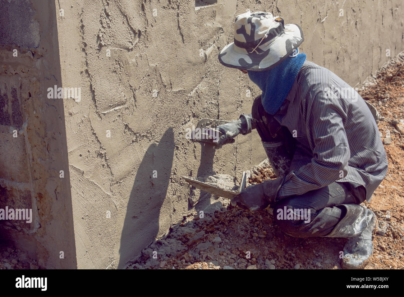 Construction workers plastering building wall using cement plaster ...