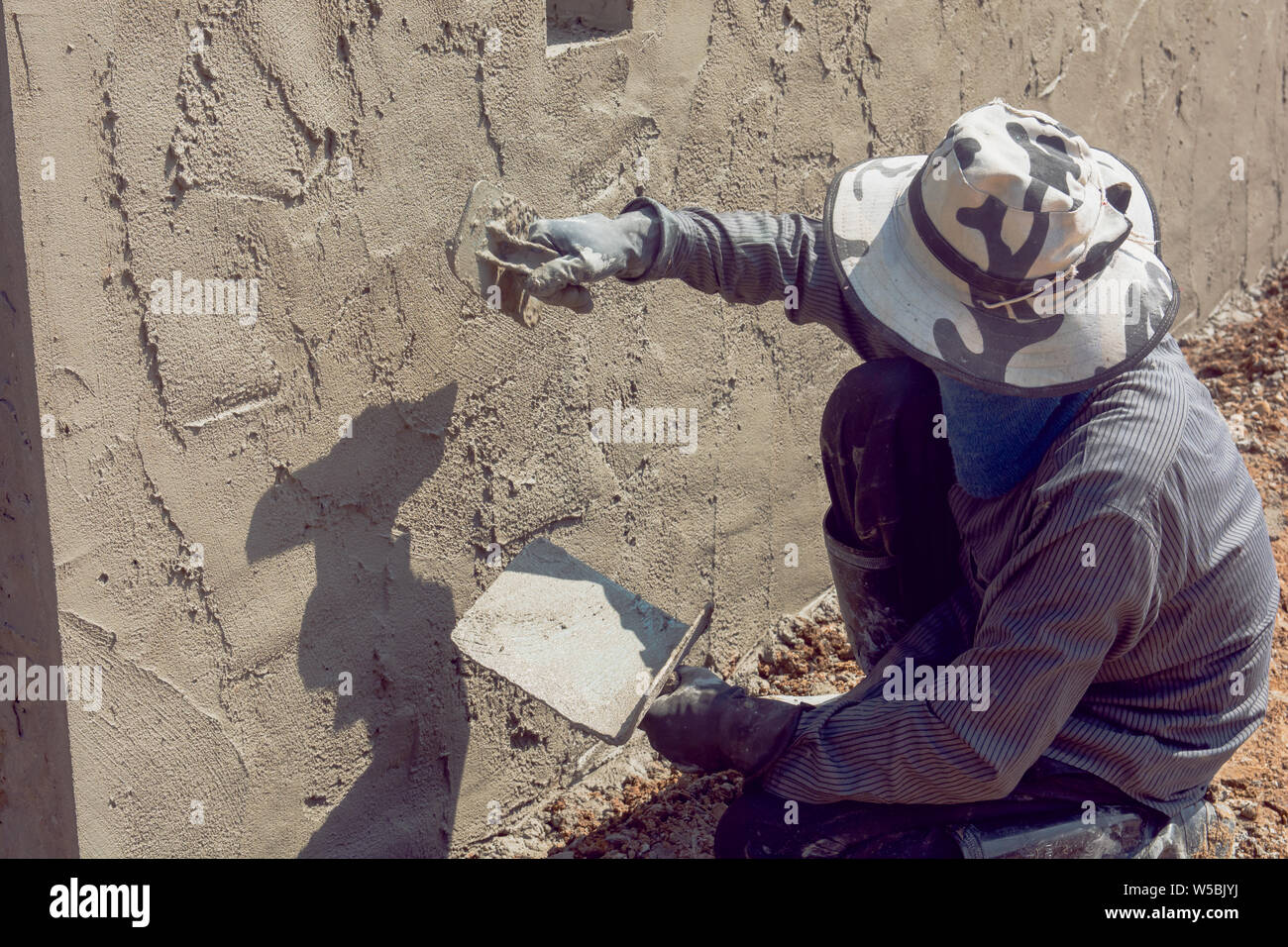 Construction workers plastering building wall using cement plaster ...
