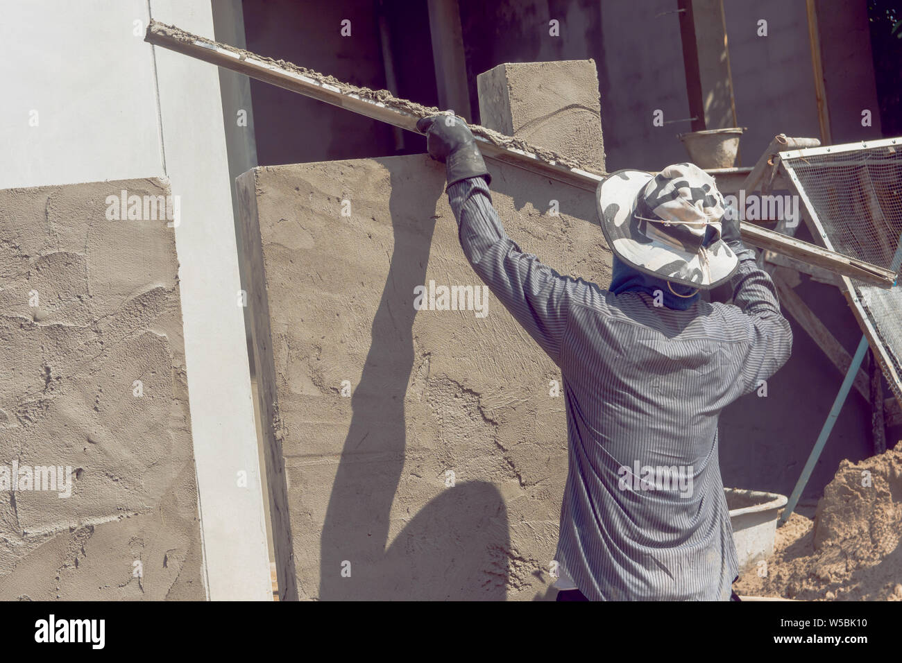 Construction workers plastering building wall using cement plaster ...