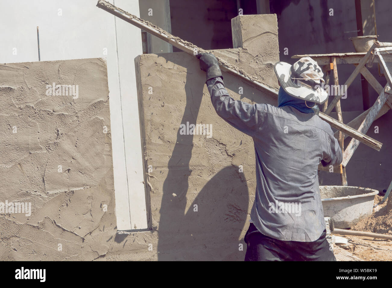 Construction workers plastering building wall using cement plaster ...